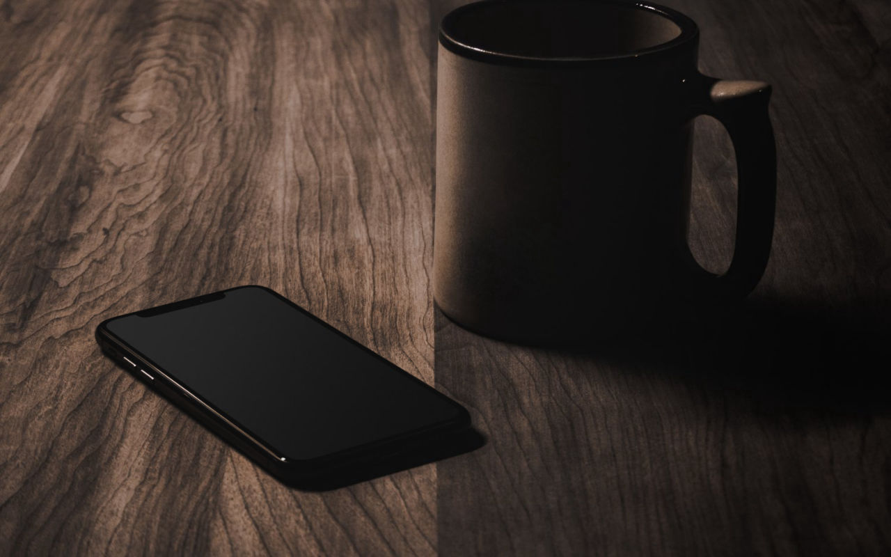 iPhone X and mug on table mockup | MockupsJar
