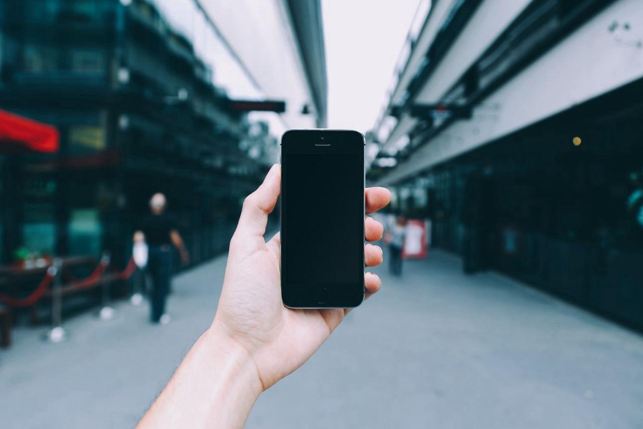 Man holding black iPhone mockup | MockupsJar